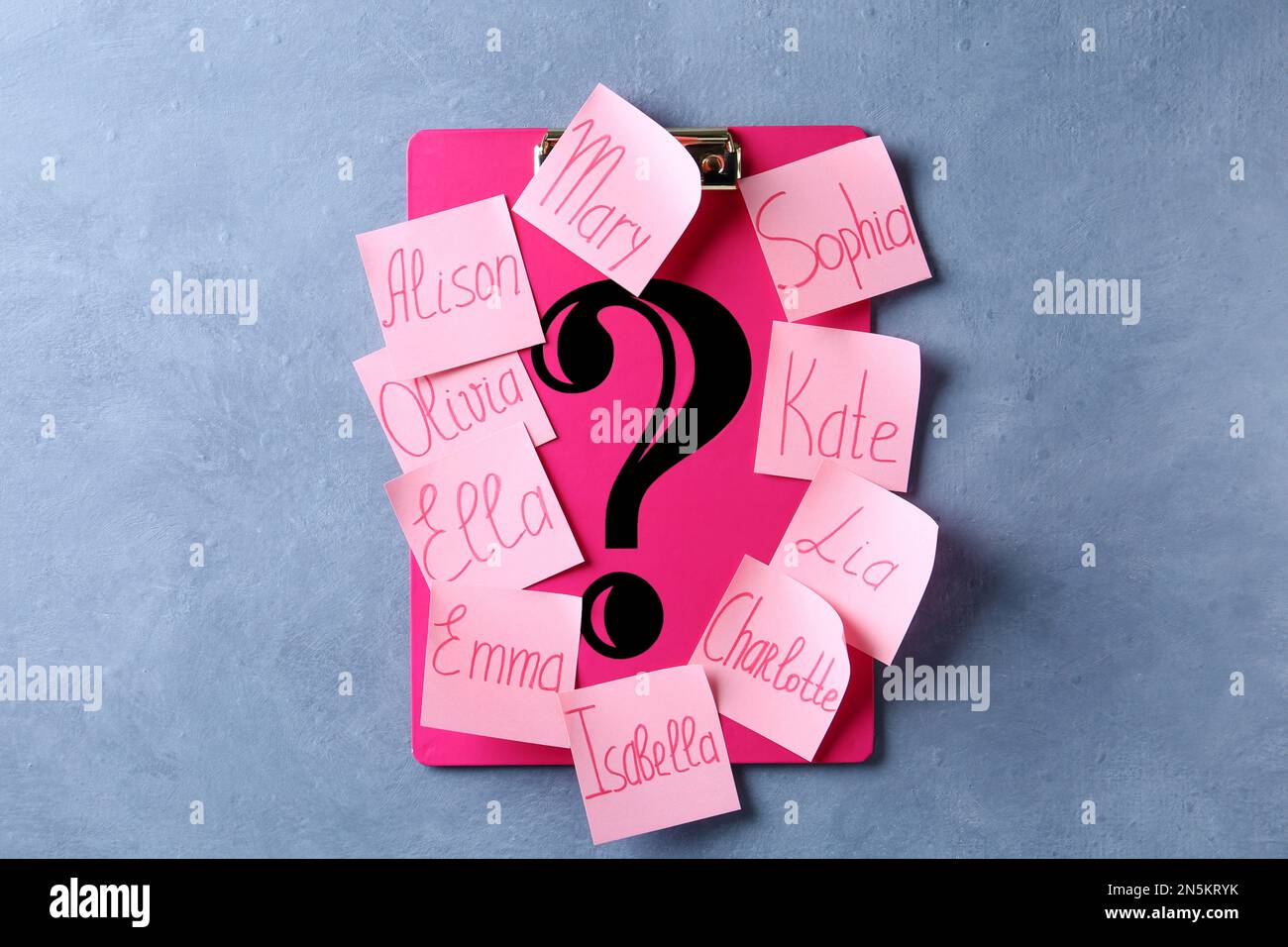 Question mark and paper notes with different baby names on blue ...