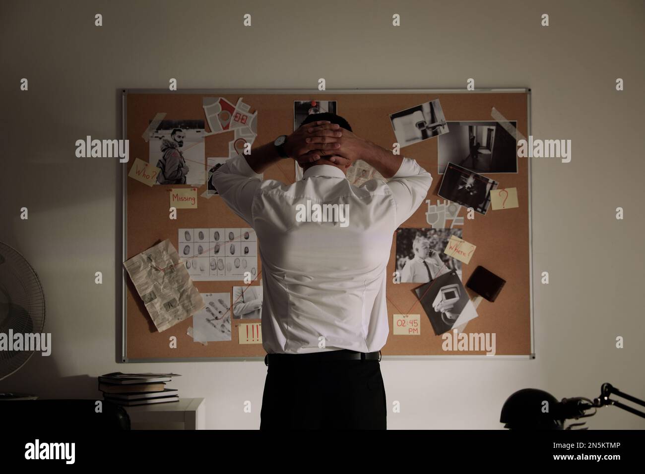 Detective looking at evidence board in office Stock Photo - Alamy