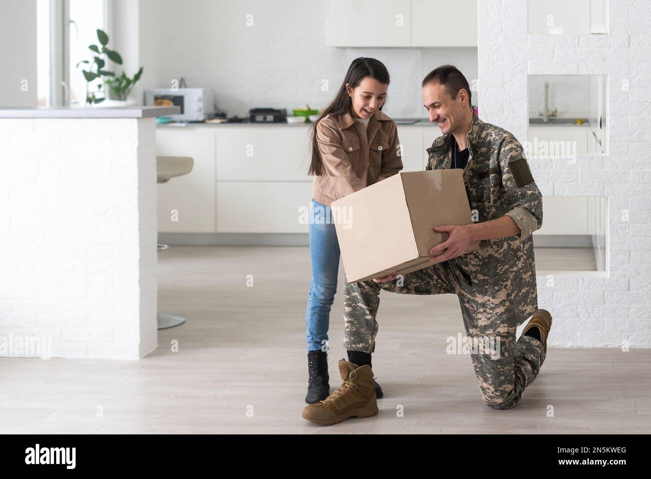 Military parents with daughter hugging, near cardboard boxes Stock ...