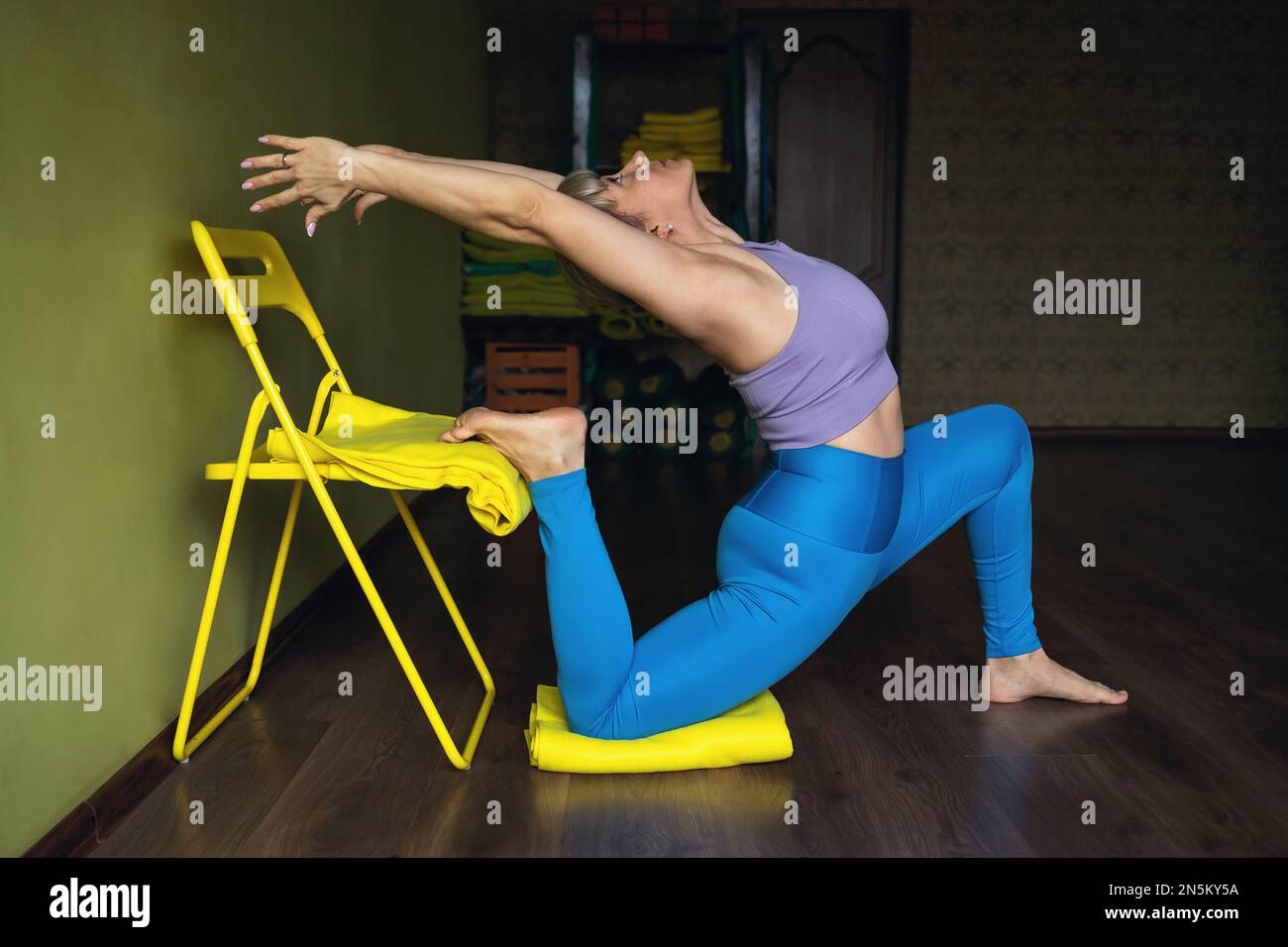 Woman leading a healthy lifestyle and doing yoga, performs a variation ...