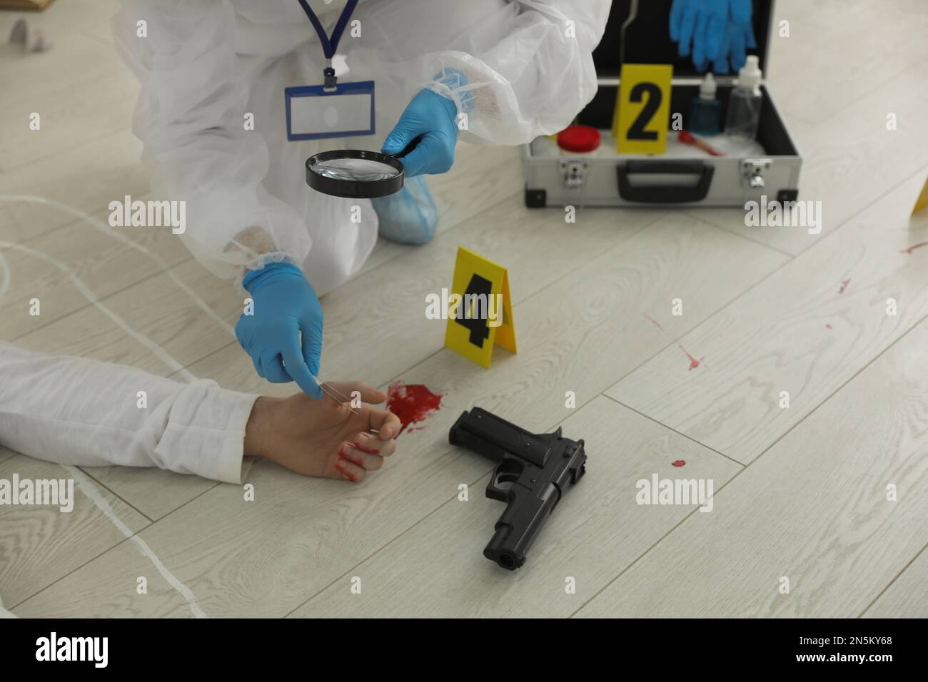 Investigator in protective suit working at crime scene with dead body ...