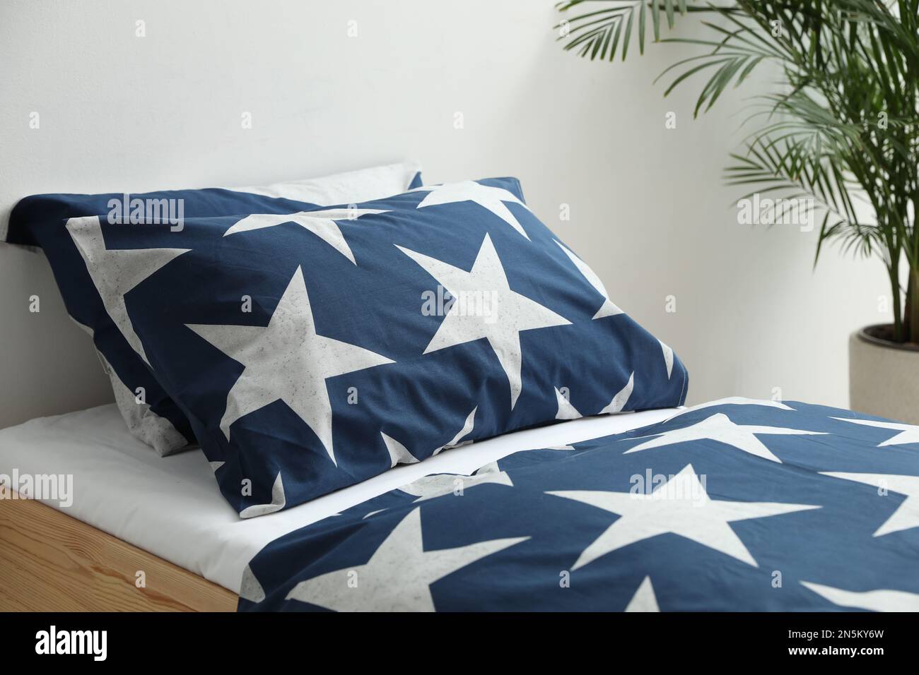 Bed with stylish linens in children's room Stock Photo - Alamy