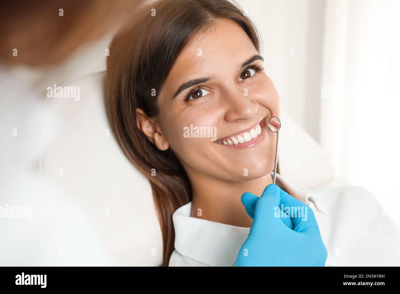 Dentist examining young patient's teeth hi-res stock photography and ...
