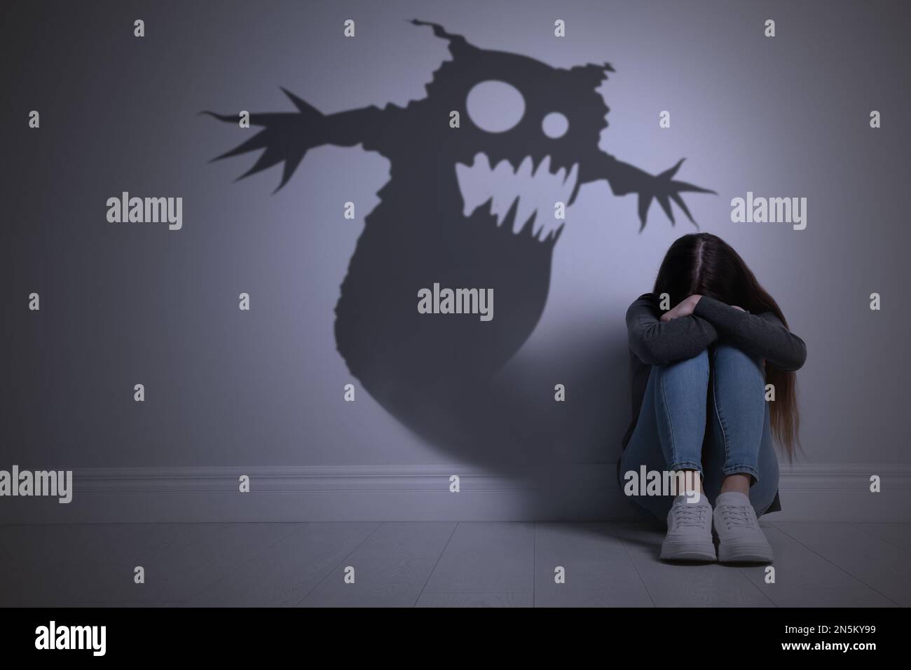 Shadow of monster on wall and scared teenage girl in room Stock Photo ...