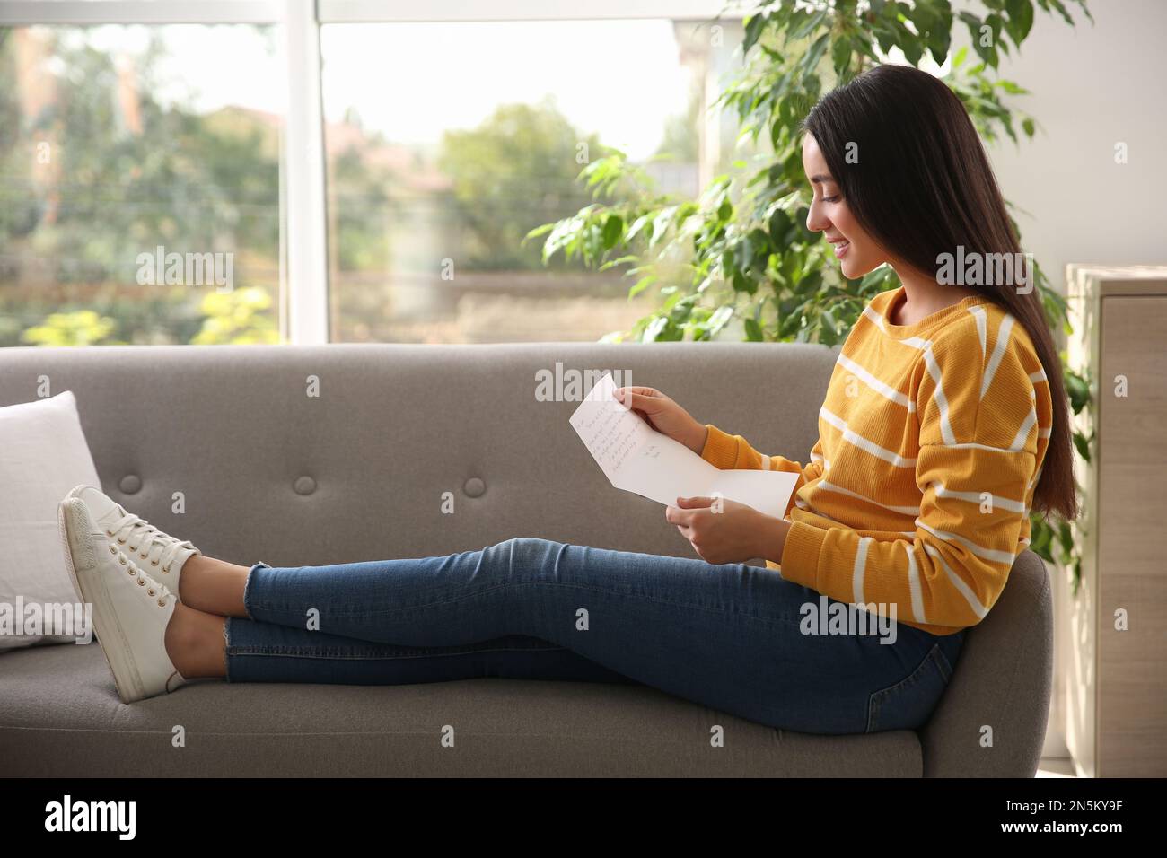 Woman reading letter on sofa hi-res stock photography and images - Alamy