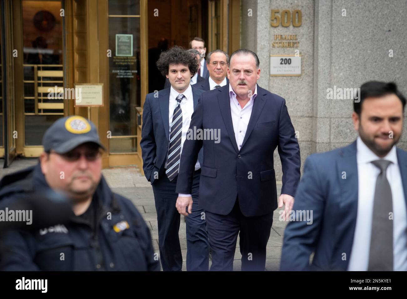 Samuel Bankman-Fried, center left, departs Manhattan federal court in ...