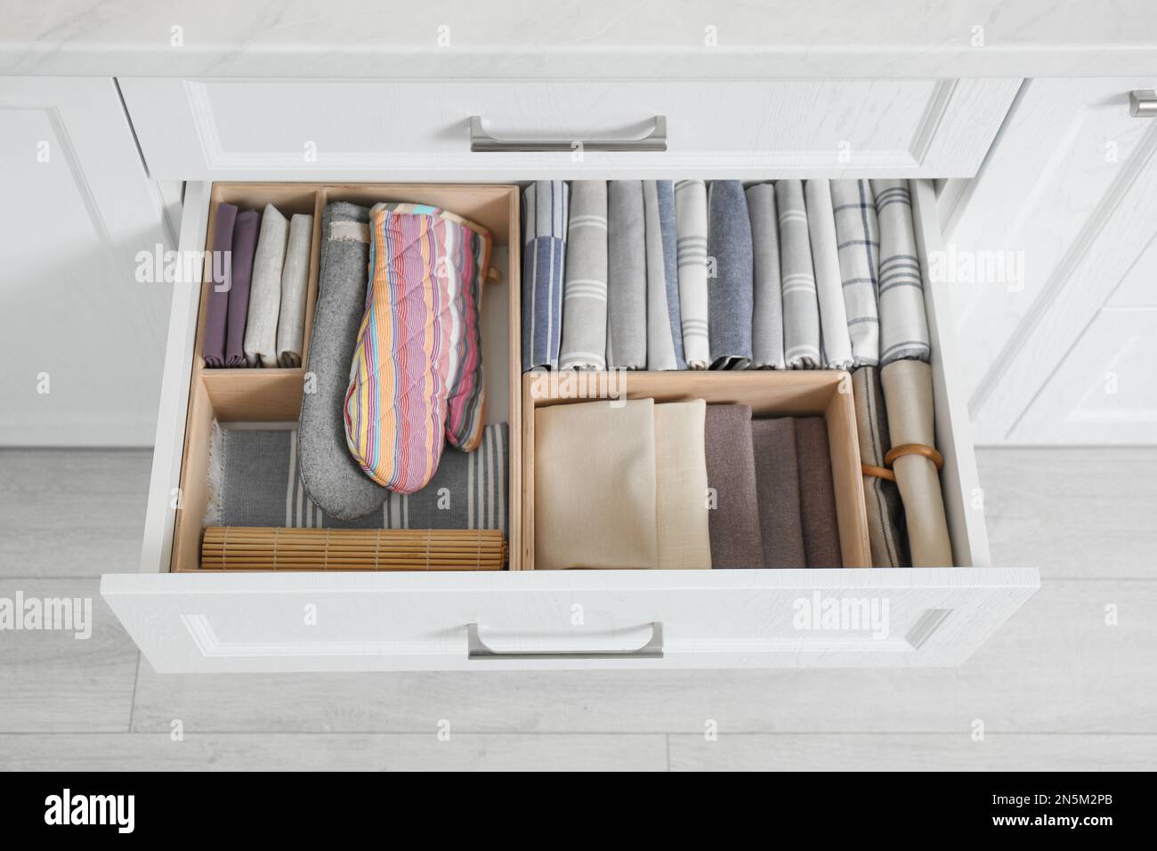 Open drawer with different textiles in kitchen, above view Stock Photo ...
