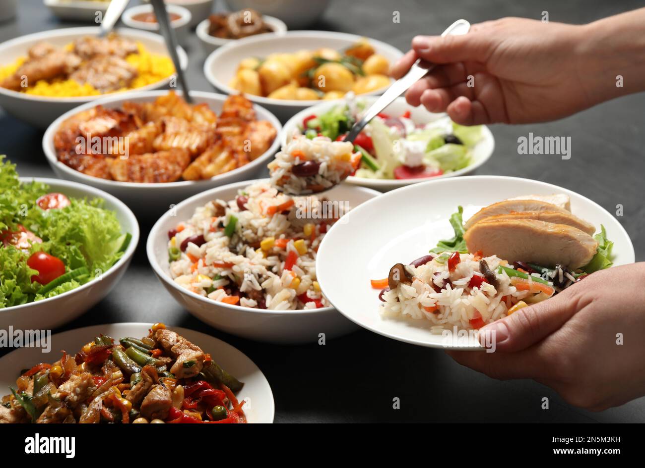 Woman taking food from buffet table, closeup Stock Photo - Alamy