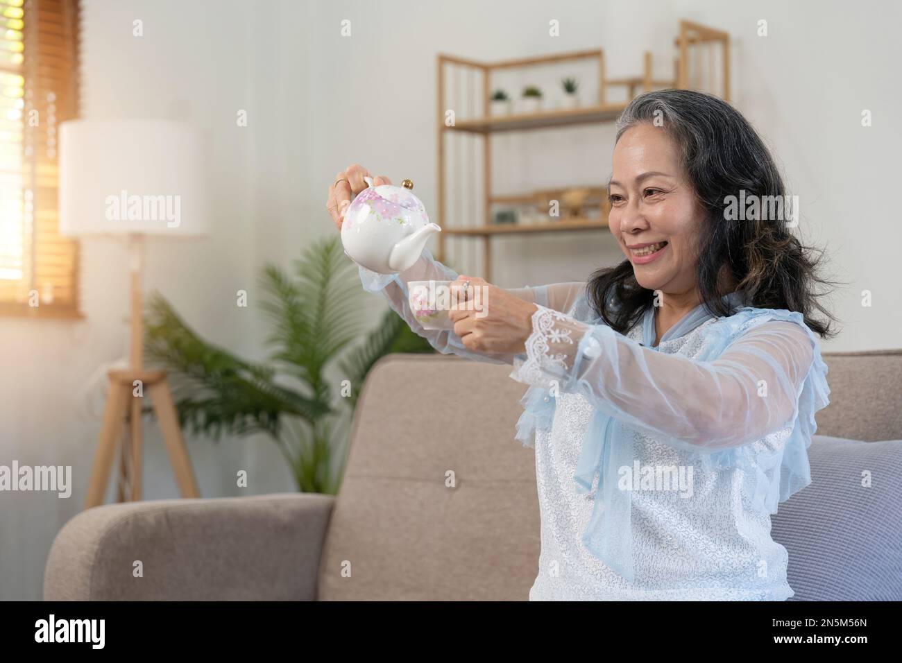 Happy old woman drinking healthy tea at home Stock Photo - Alamy