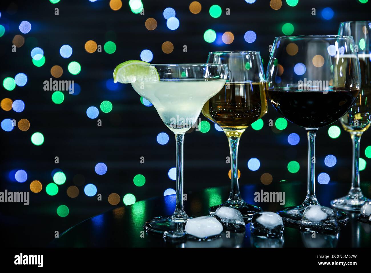 Many different alcoholic drinks on table against dark background with ...