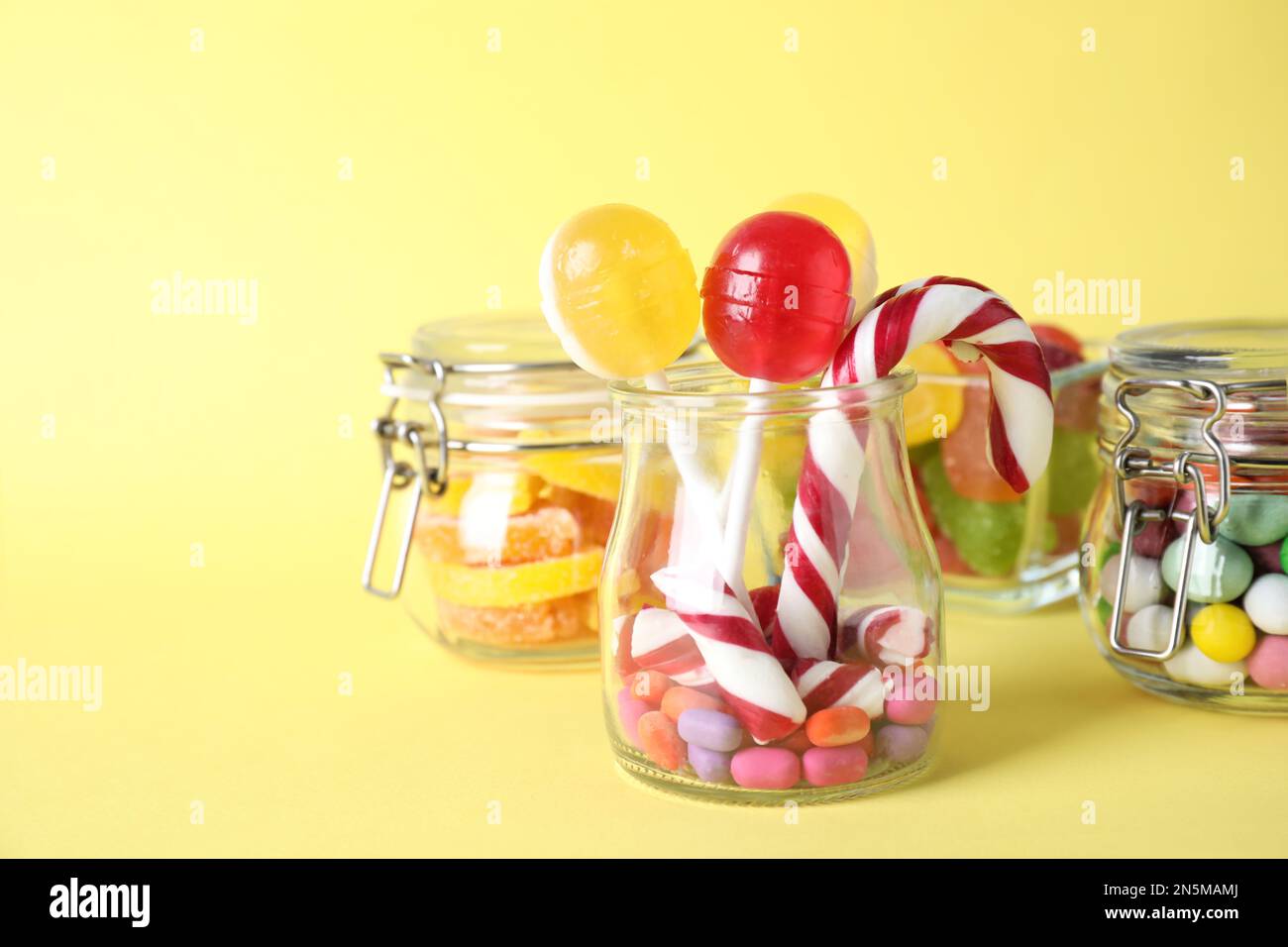 Different yummy candies on yellow background. Space for text Stock ...