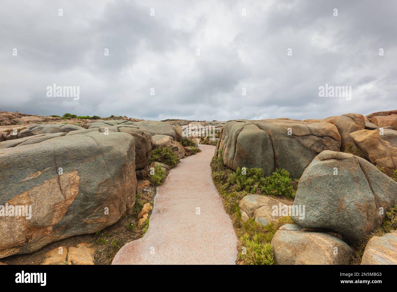 Access road between large boulders and plants to tourist interesting ...