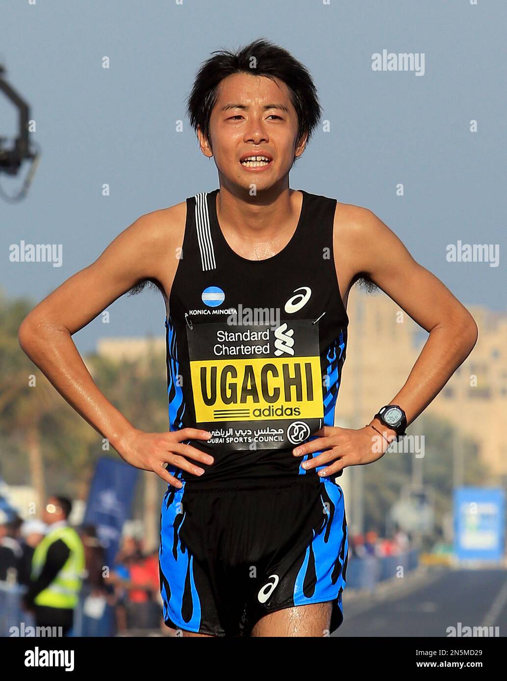Japanese runner Tsuyoshi Ugachi crosses the finish line at the Standard Chartered Dubai Marathon ...