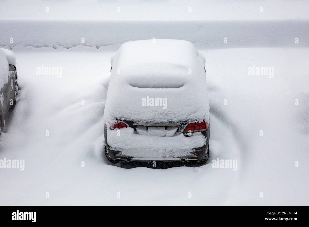 Car under a thick layer of snow. Snow-covered vehicles during a winter ...