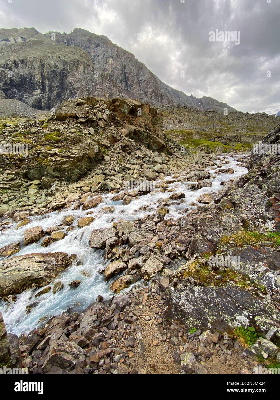 Alpine stream flows over rocks near mountains in Altai in Siberia in ...