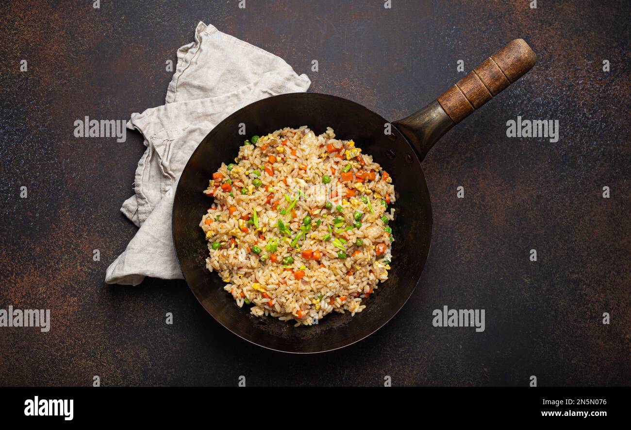 Authentic Chinese and Asian fried rice with egg and vegetables in wok ...