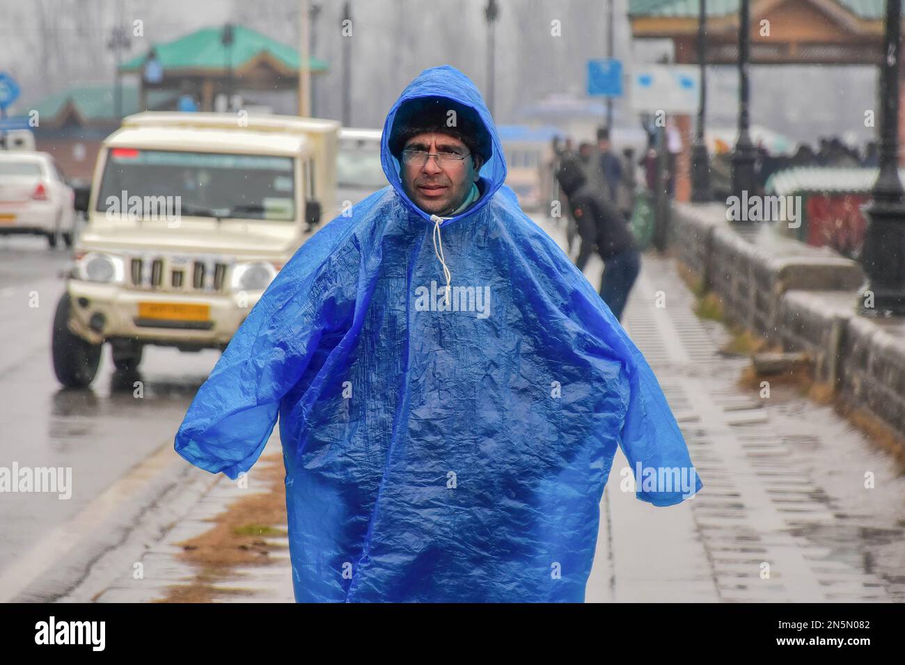 Srinagar, India. 9th Feb, 2023. A man seen wearing a raincoat walks on ...