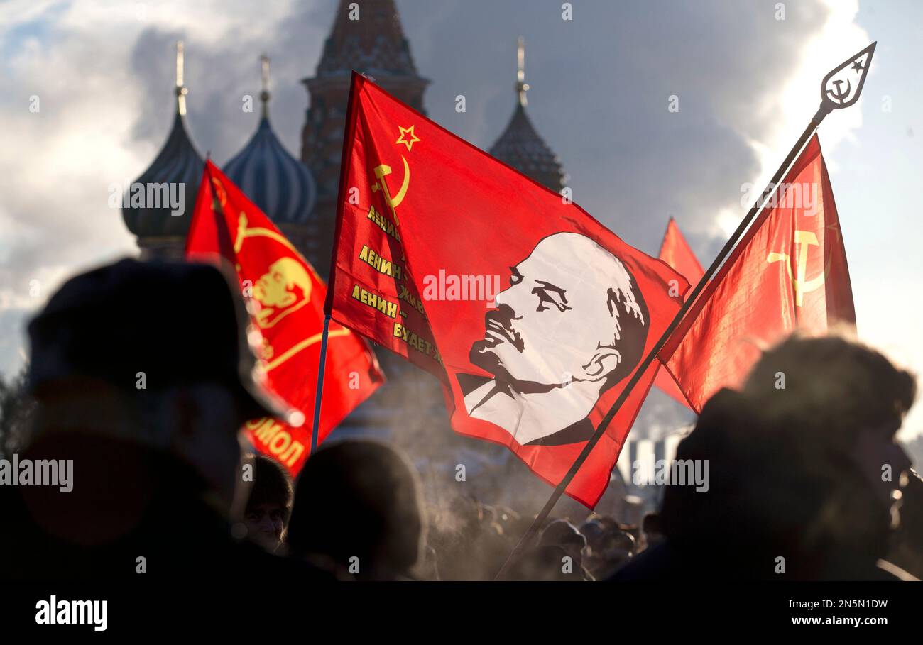 Russian Communists, carrying red flags with portrait of Soviet founder ...