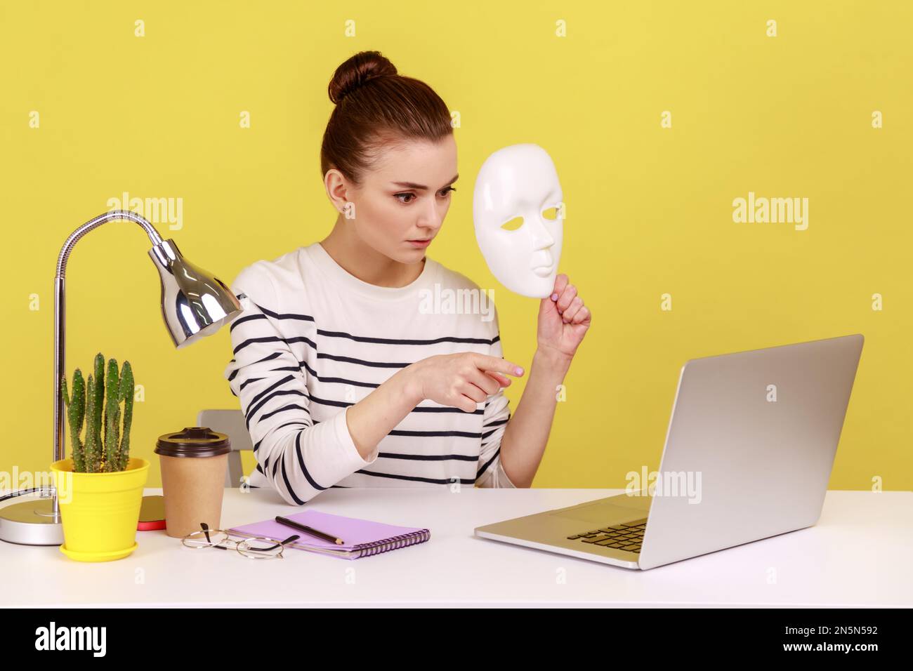 Strict woman office worker holding white face mask and pointing finger ...