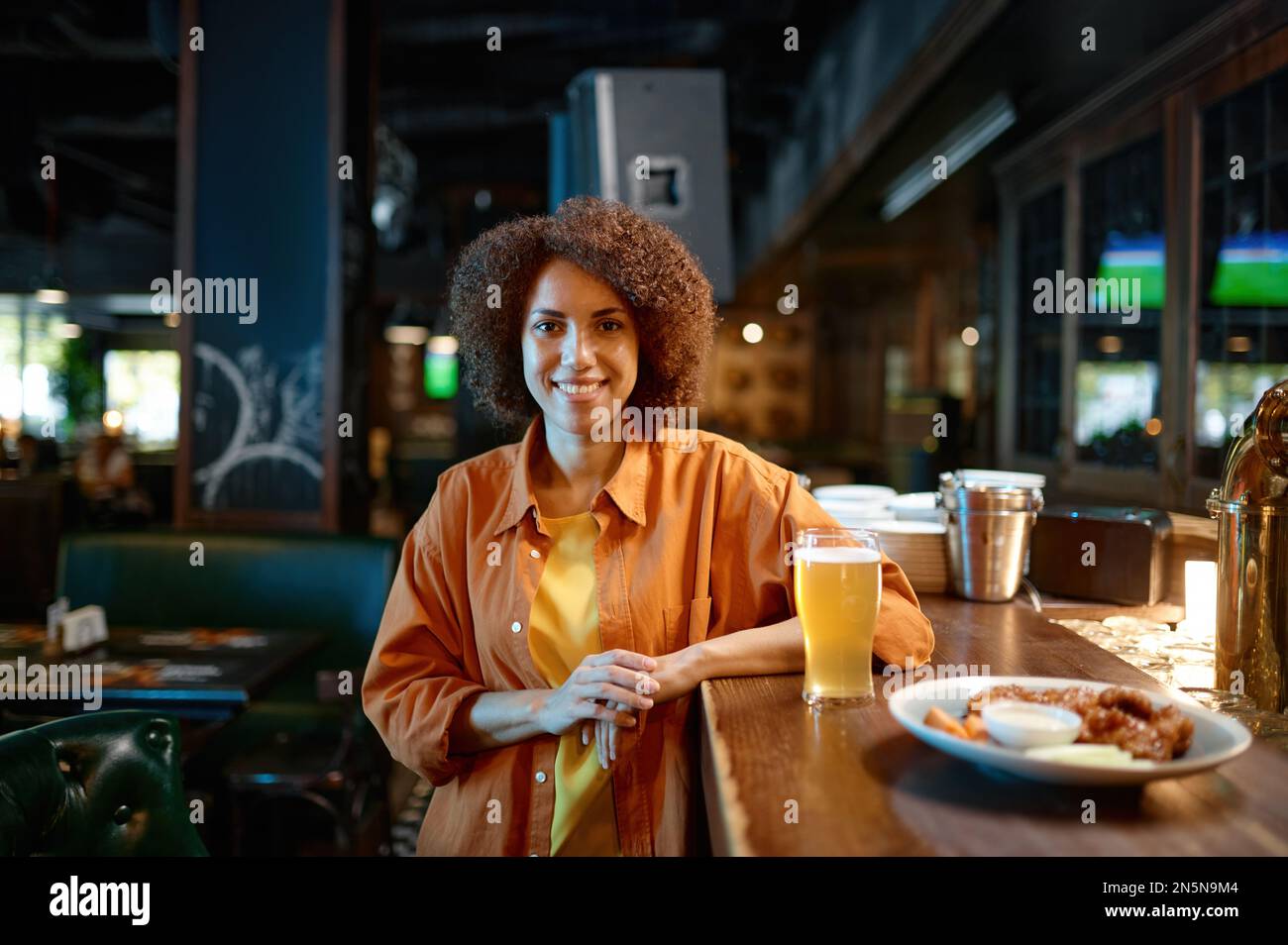 Portrait of smiling pretty woman at sports bar counter desk Stock Photo ...