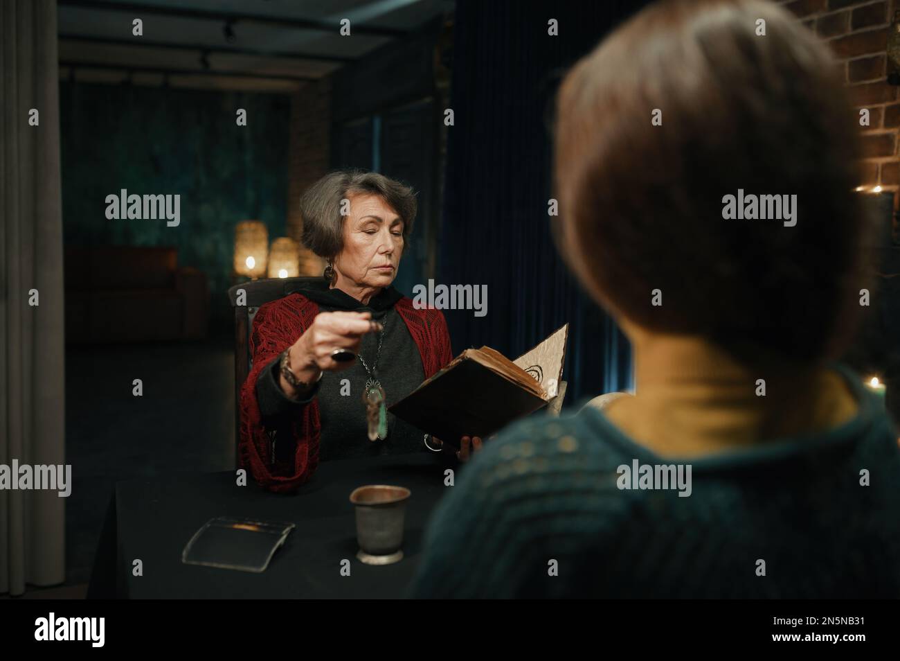 Gypsy reading spell for client using witchcraft book and magic pendulum ...