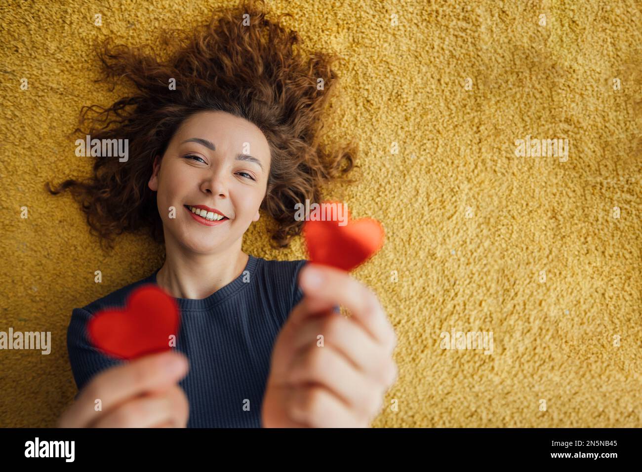 Portrait of a smiling asian woman holding two hearts, defocused Stock ...