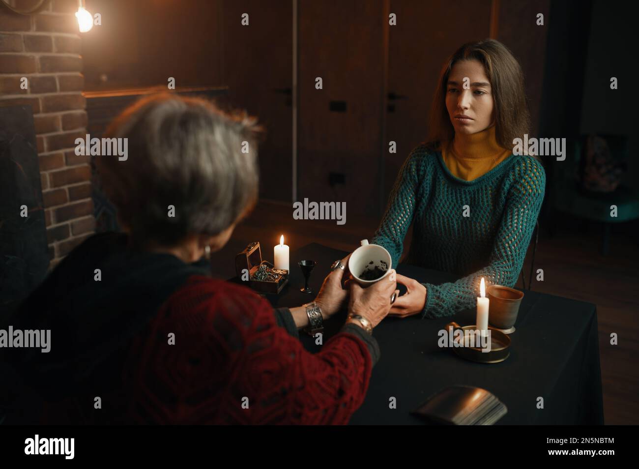 Young woman visiting gypsy witch for divination on coffee grounds Stock ...