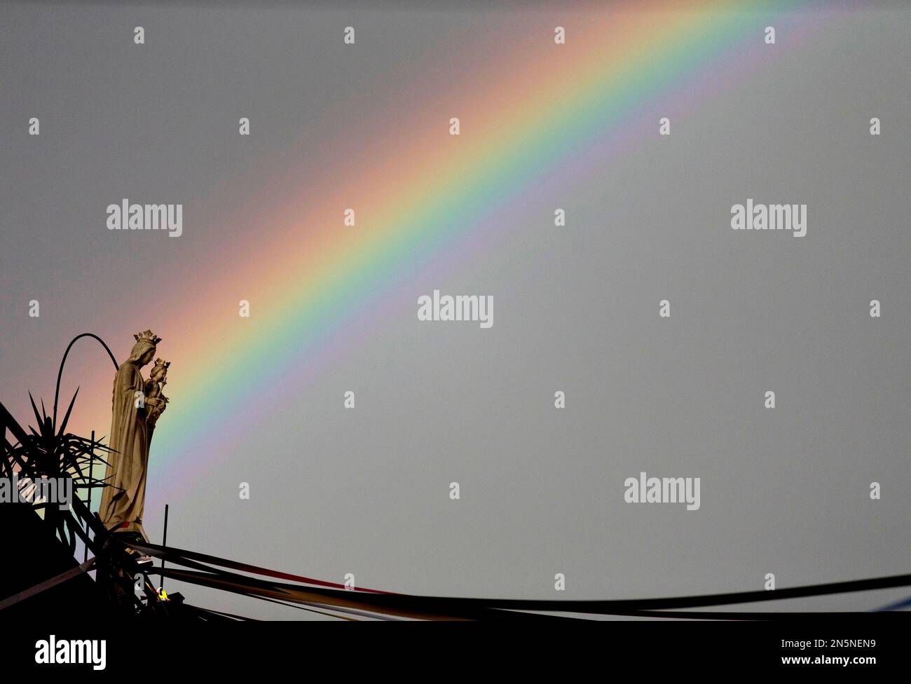 A rainbow frames the Virgin Mary statue placed on the top of the Sacro ...