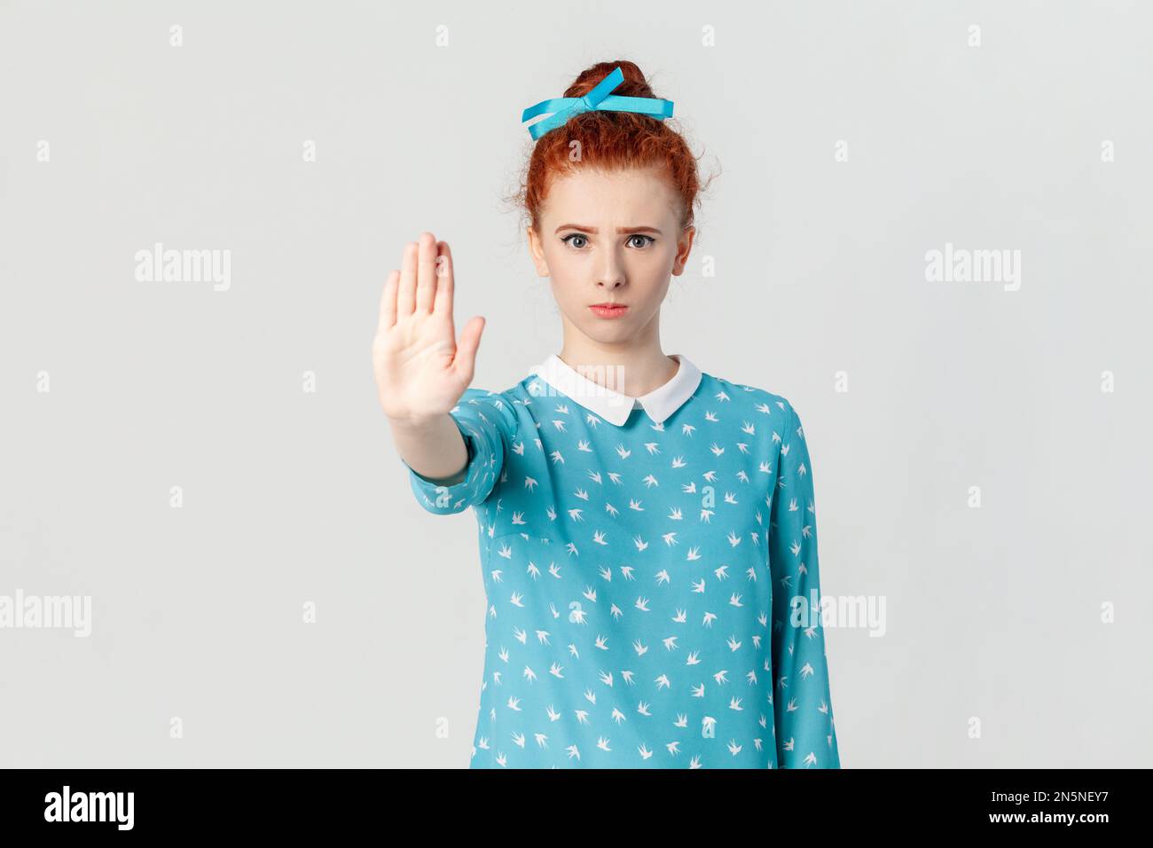 Portrait of strict bossy red haired woman with bun hairstyle, standing ...