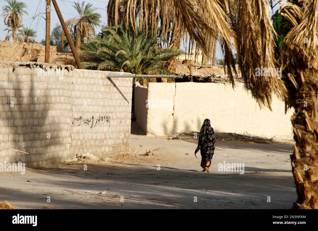 A woman from the Tabu ethnic group walks along a street in Murzuq ...