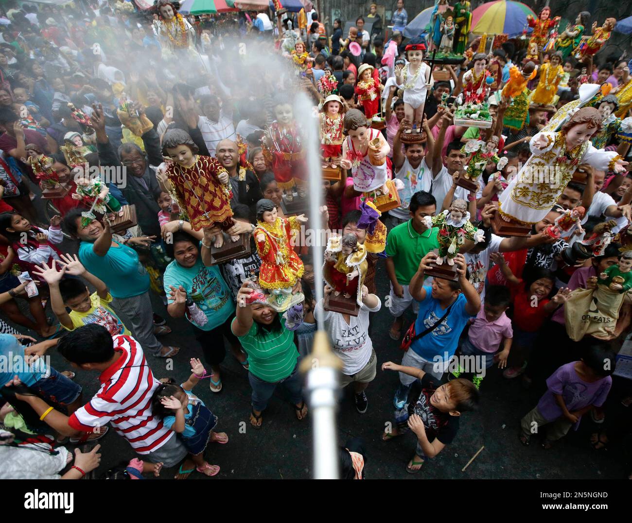 Catholic devotees raise their images of the Infant Jesus known as Sto ...