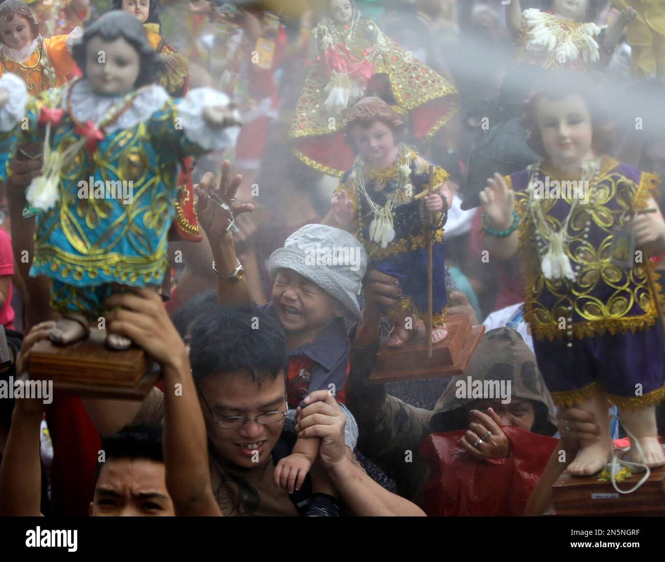A child is raised along with images of the Infant Jesus known as Sto ...