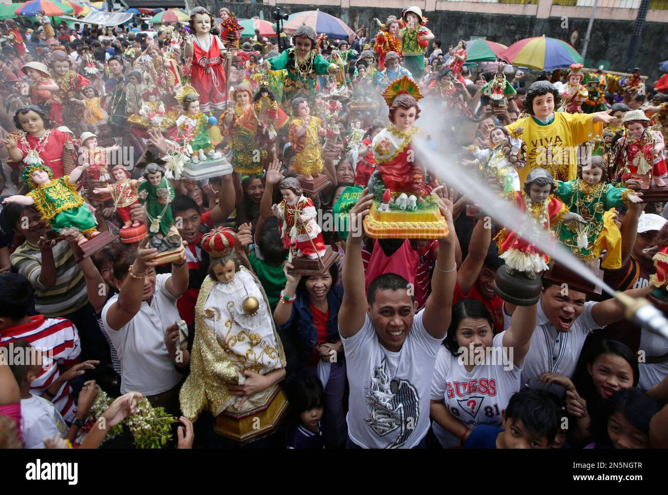 Catholic devotees raise their images of the Infant Jesus known as Sto ...