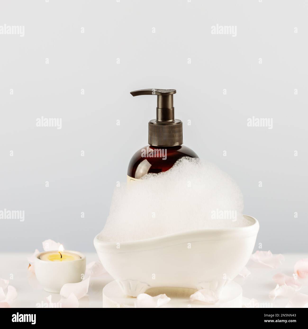 Spa relax composition with cosmetic bottle, soap foam, candles and rose ...