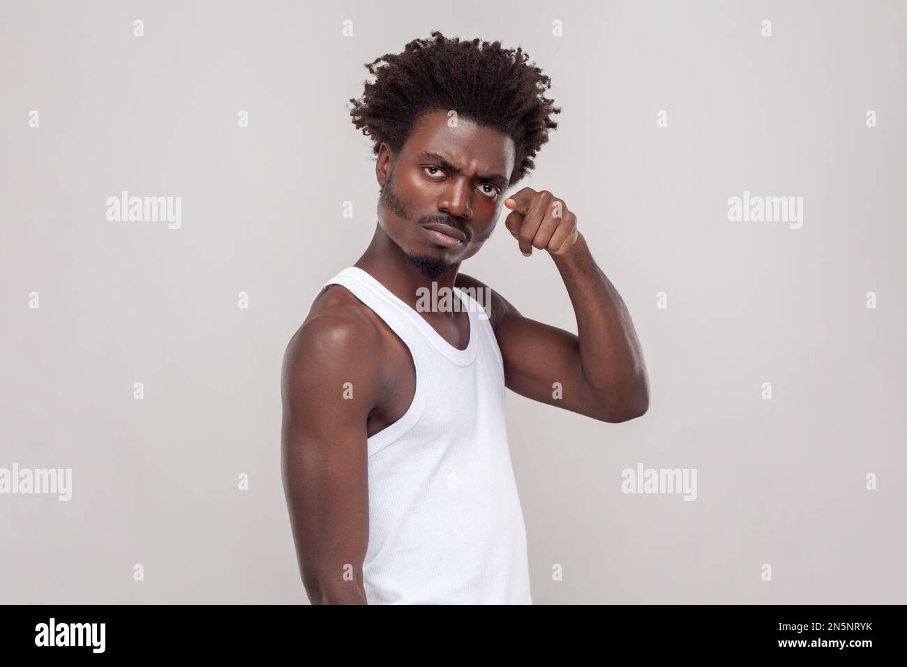Portrait of serious strict angry man with Afro hairstyle points index ...
