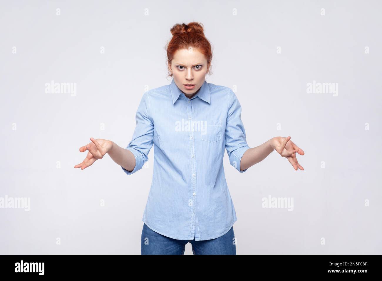 Portrait of unhappy frustrated ginger woman wearing blue shirt ...