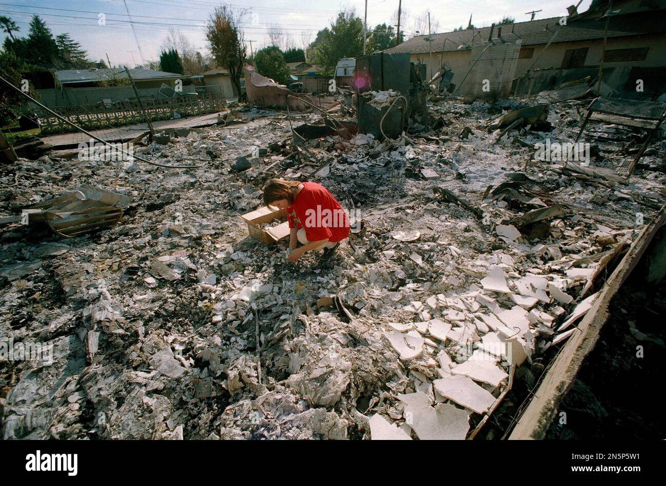 Maria Partlow sifts through the remains of her home that burned after ...