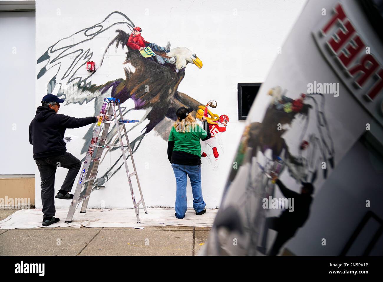 Artist Meg Saligman, right, accompanied by Edward Alvarez paint a new ...