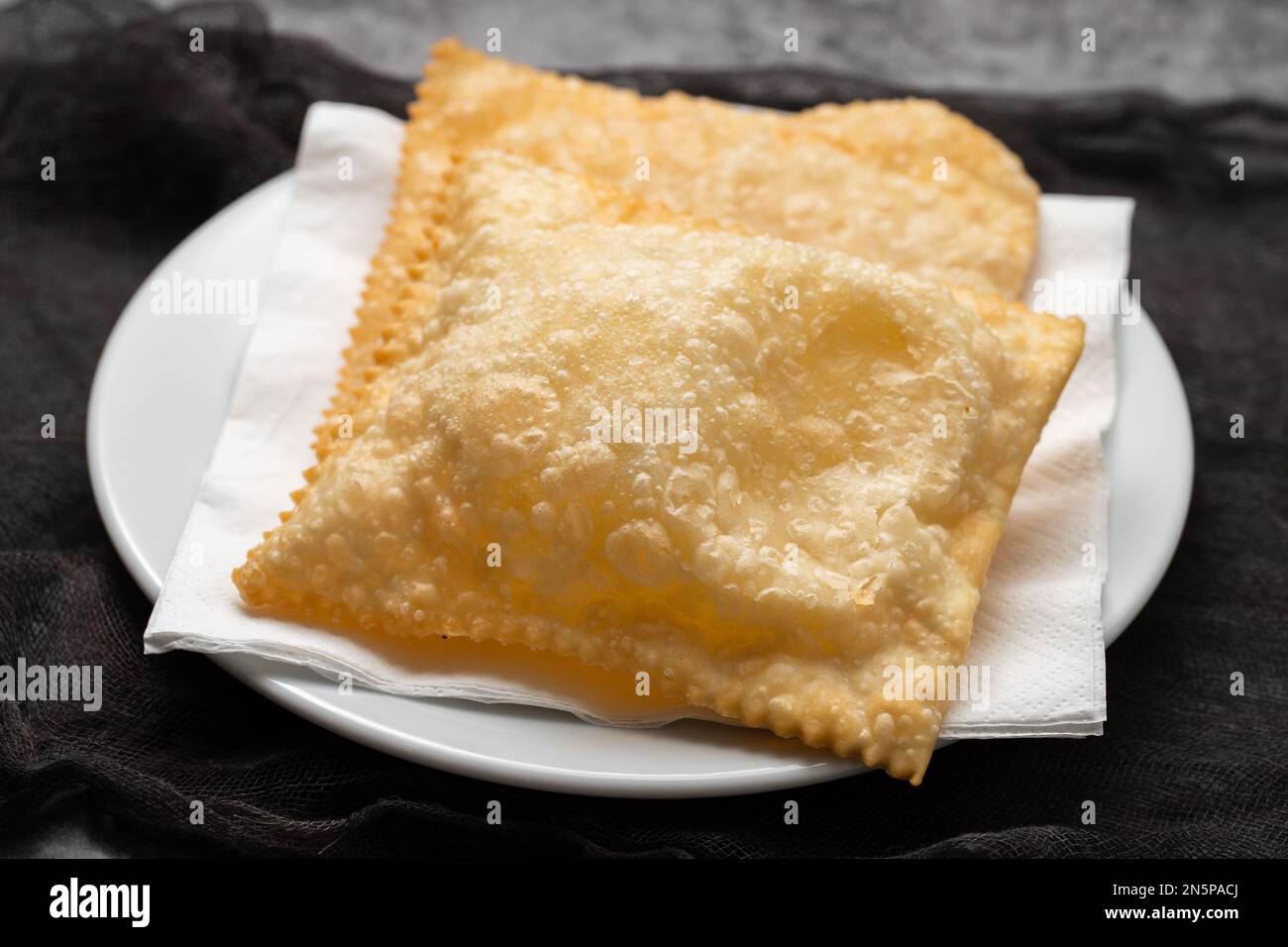 typical brazilian fried pastry on white small plate Stock Photo - Alamy