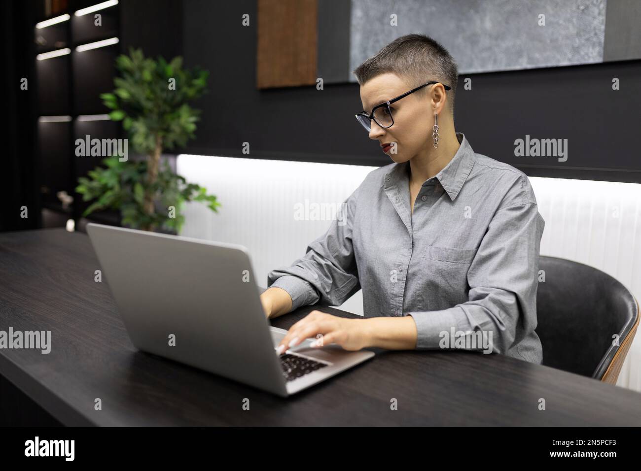 successful woman programmer working in a stylish office behind a laptop ...