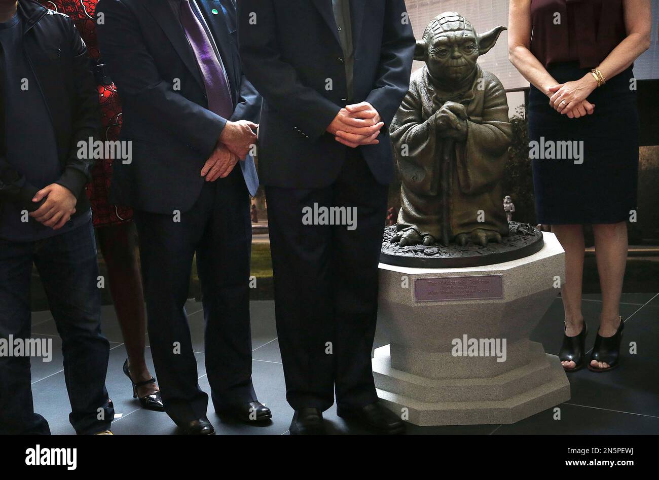 Guests pose with a bronze statue of "Yoda" a charactor from "Star Wars ...