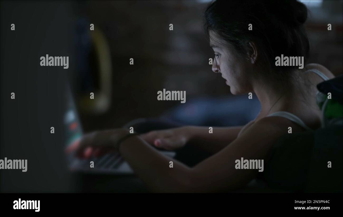 Candid woman working at night in front of laptop. Female person ...