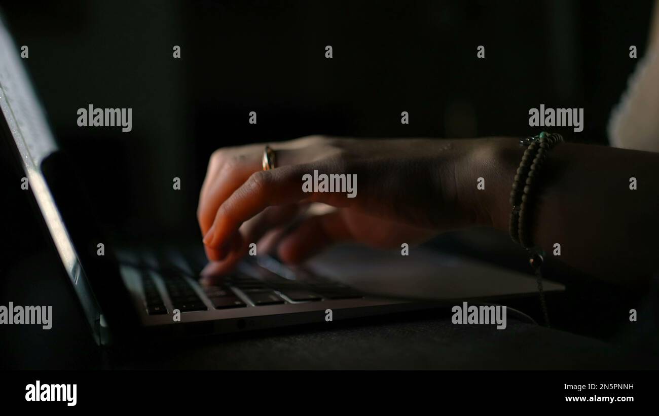 Closeup person hands typing on laptop keyboard in the dark Stock Photo ...