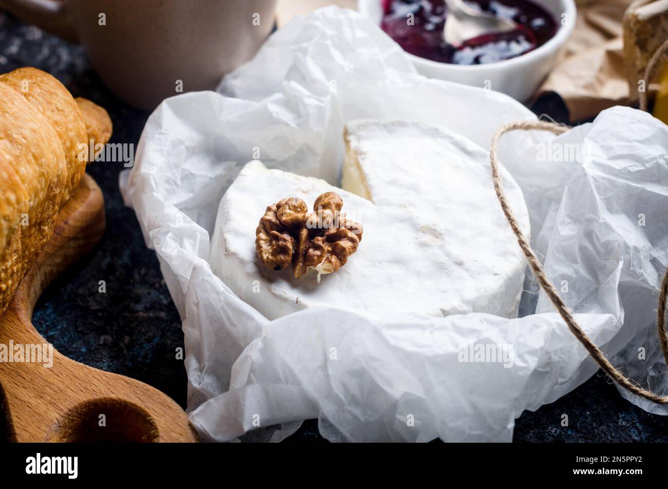 Camembert cheese close-up with honey, nuts, vine. Exquisite cheese ...
