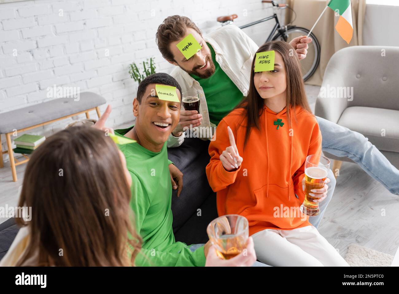 happy interracial friends with sticky notes on foreheads looking at ...