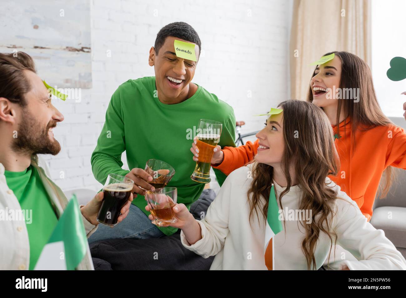 happy multiethnic friends with sticky notes on foreheads clinking ...