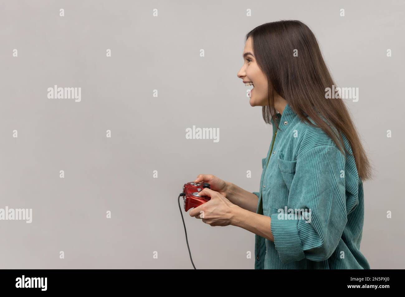 Side view of excited woman holding gamepad, winning video games ...