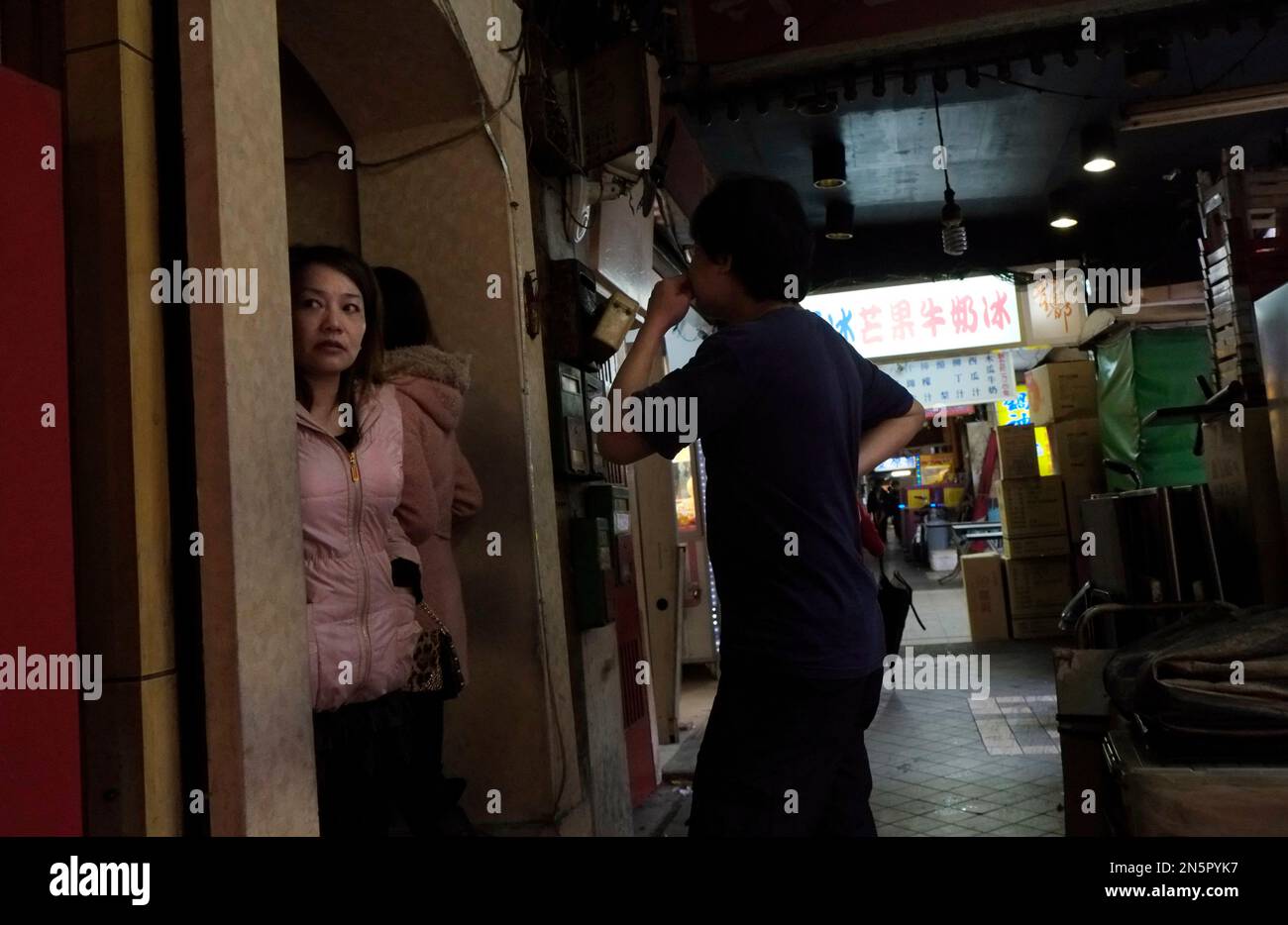 Hostesses look out for customers and police in a red light district of ...