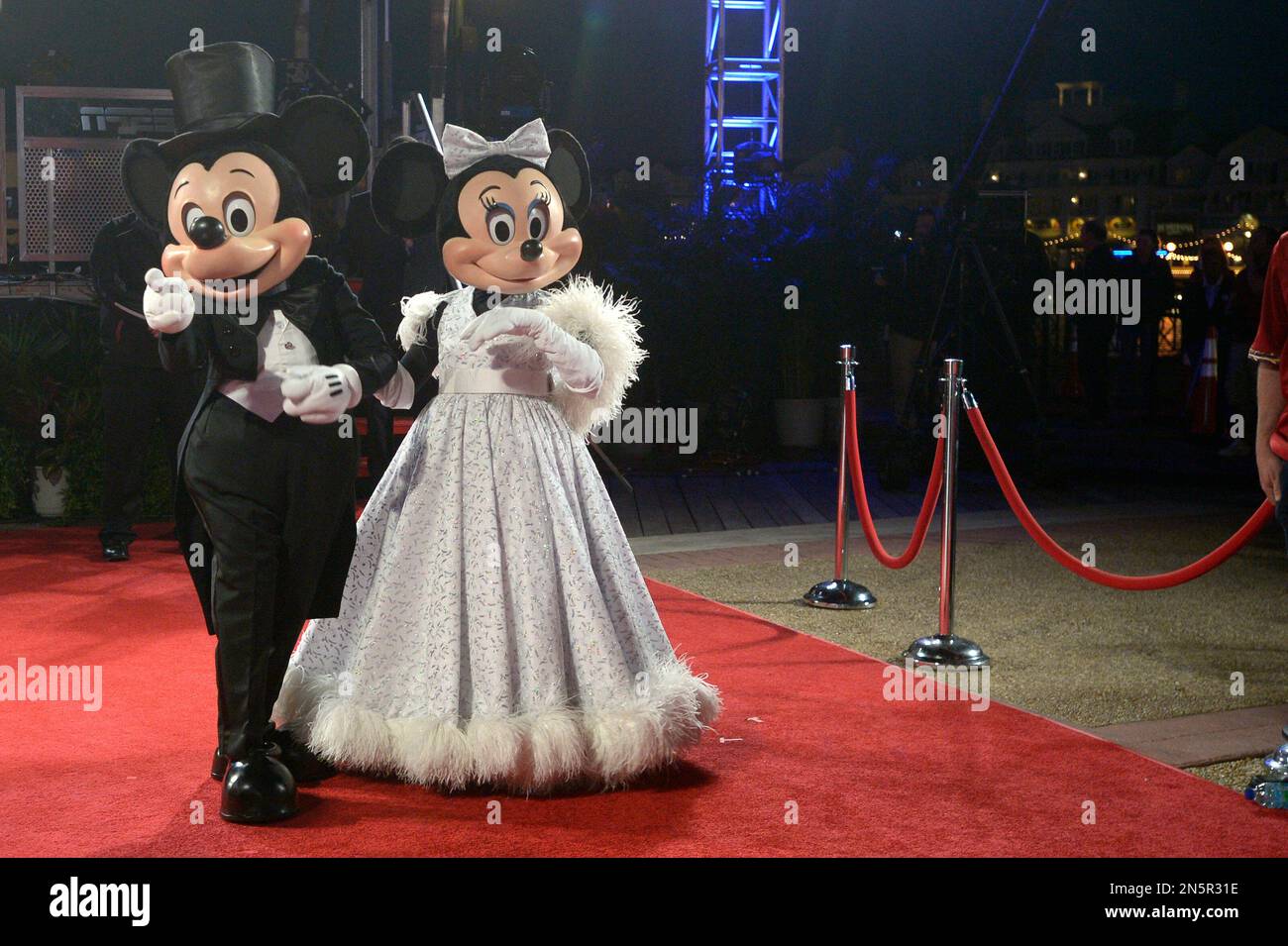 Actors dressed as Mickey Mouse, left, and Minnie Mouse greet players as ...