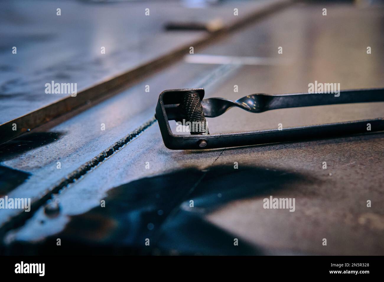 A closeup of a metal lighter gas-cutting tool on wooden surface Stock ...